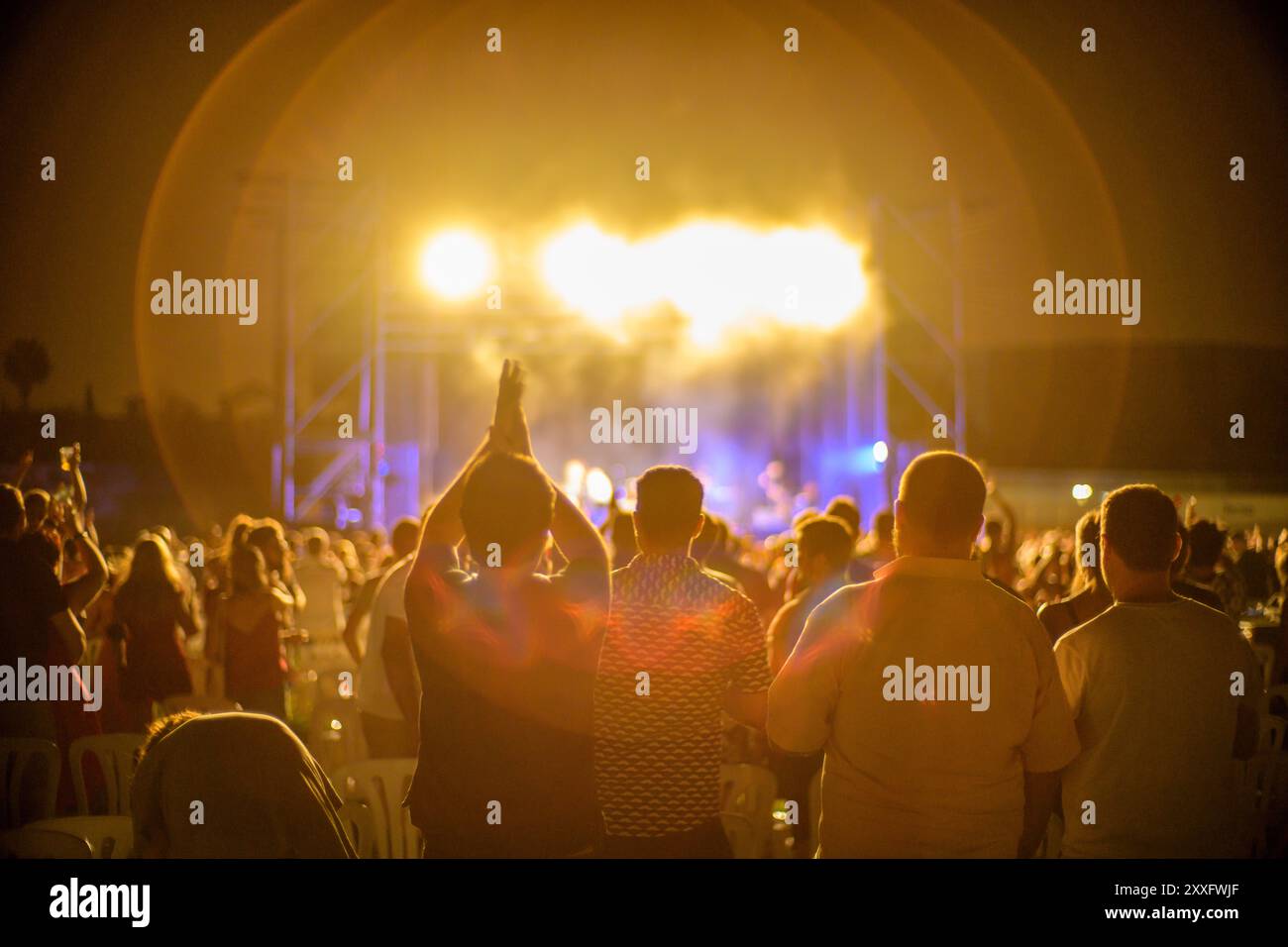 Vibrant rock concert scene with an enthusiastic crowd and bright stage ...