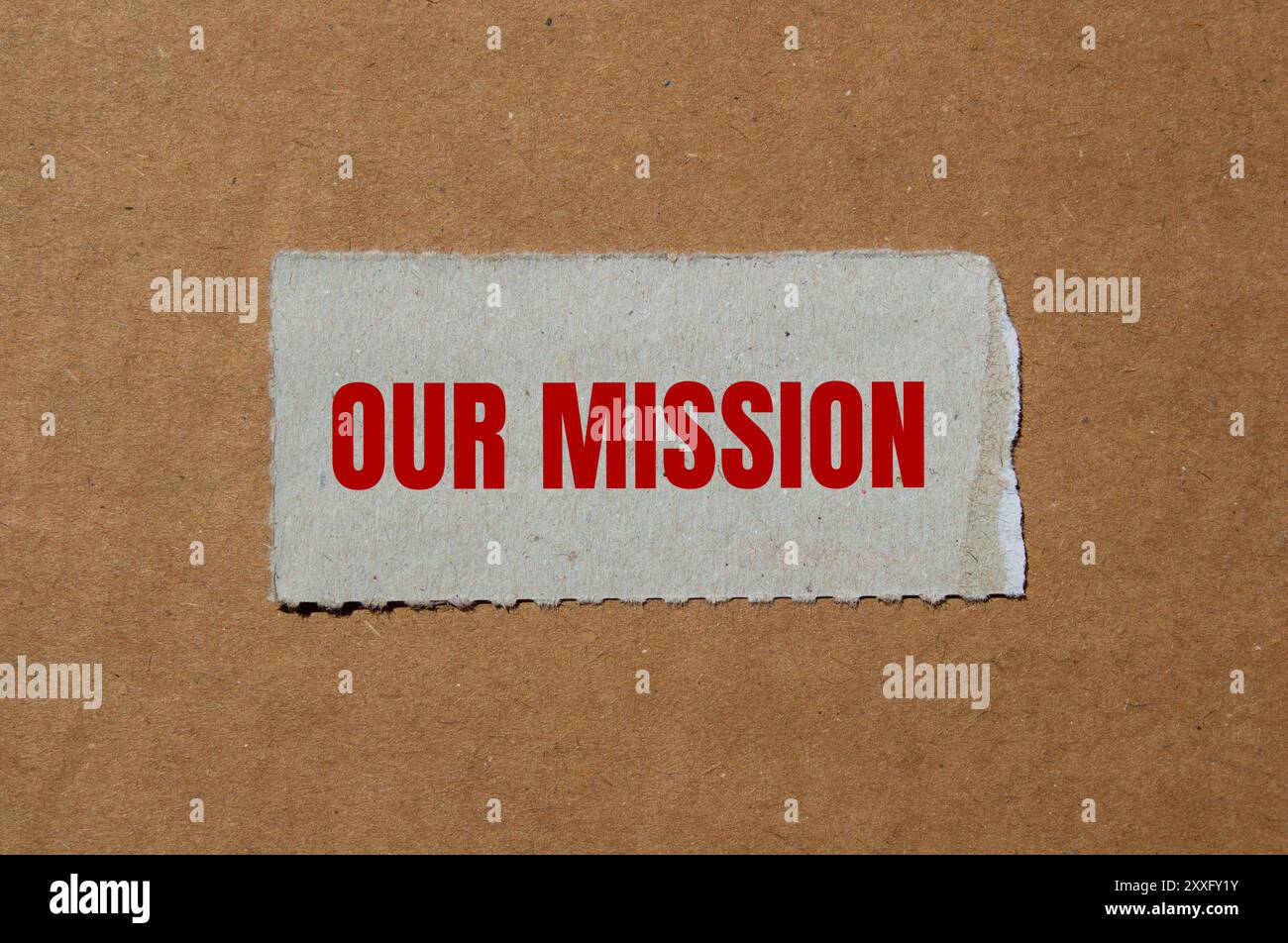 Our mission message written on ripped torn paper piece with cardboard ...