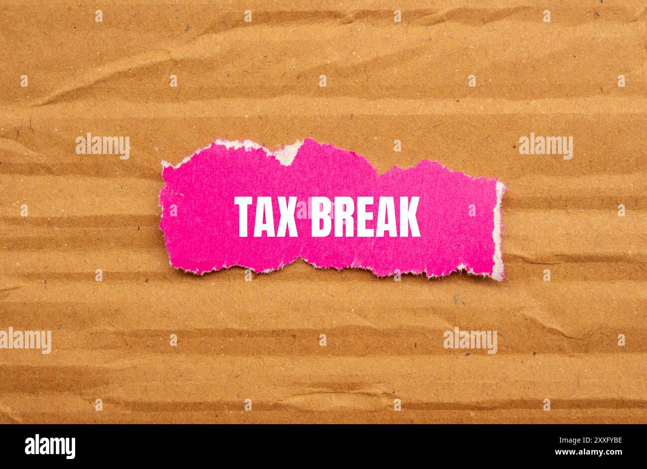 Tax break message written on ripped pink torn paper piece with ...
