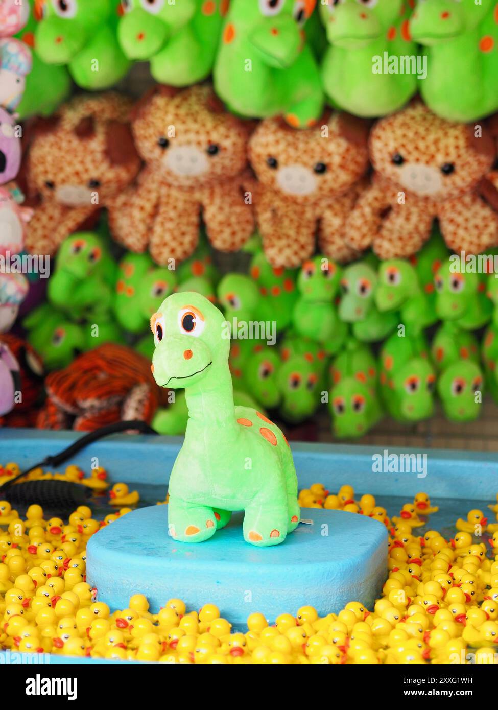 Dragon plushie toy in the amusement park with yellow ducks and lots of ...