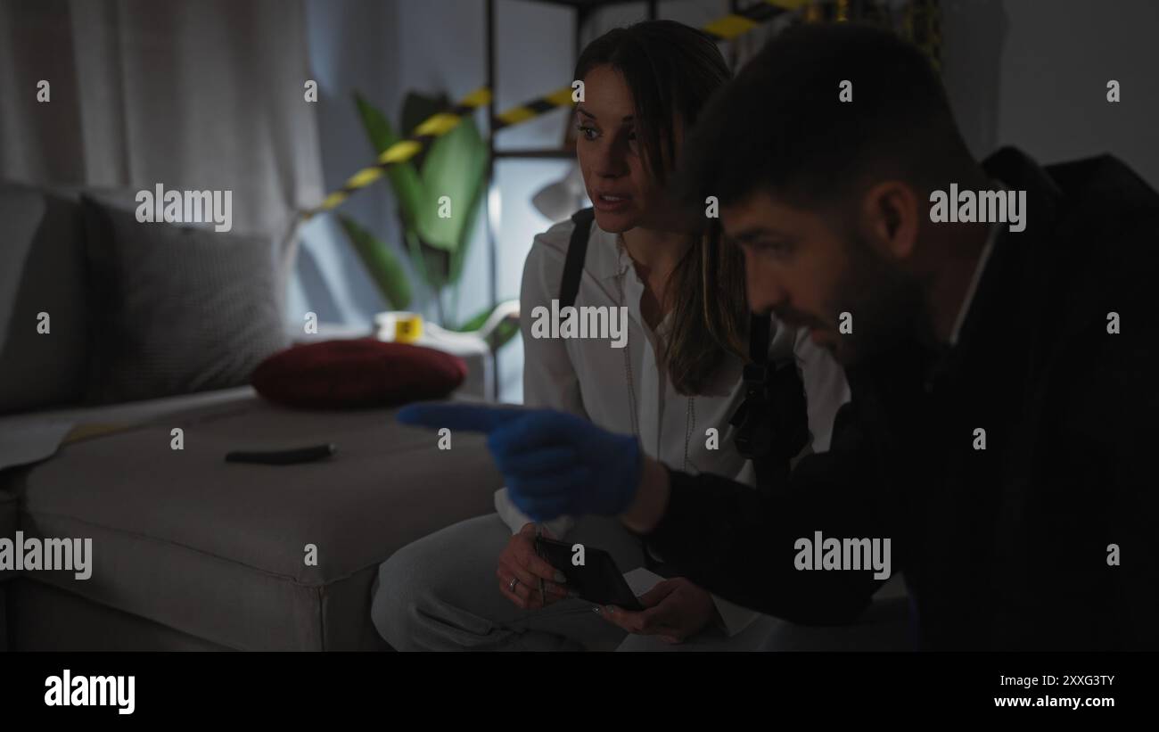 A man and woman in professional attire analyze evidence at an indoor ...