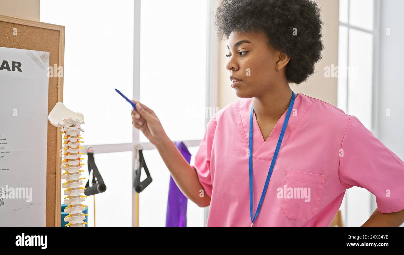 African american woman in pink scrubs teaching at a rehabilitation ...