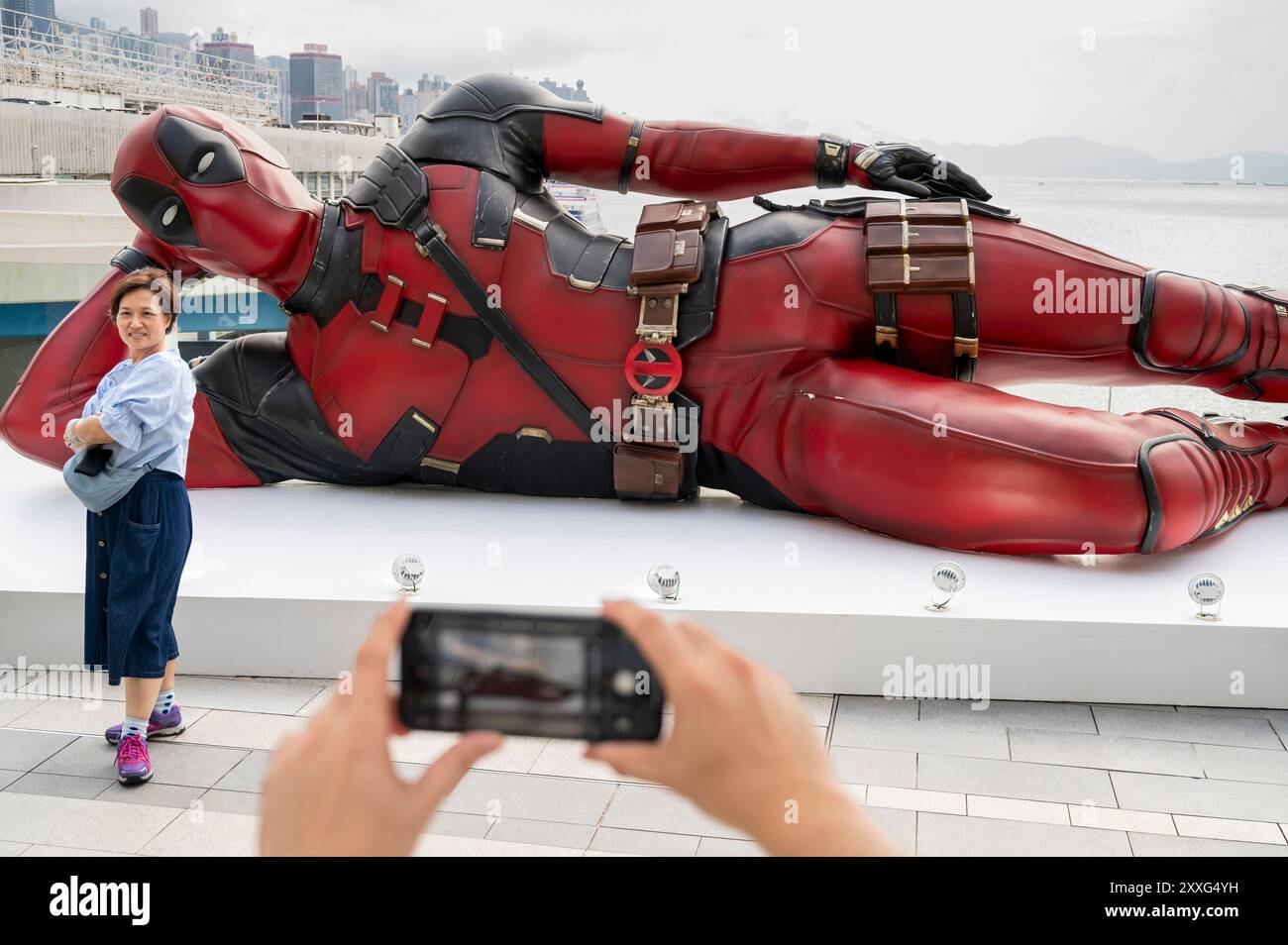 Hong Kong, China. 18th Aug, 2024. A visitor has her photo taken as she ...