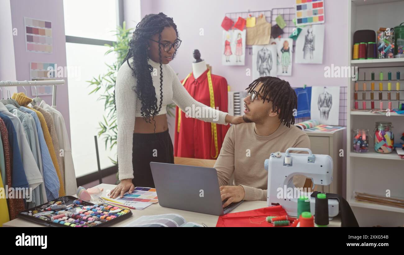 In a design room, a female dressmaker and a male designer work together ...
