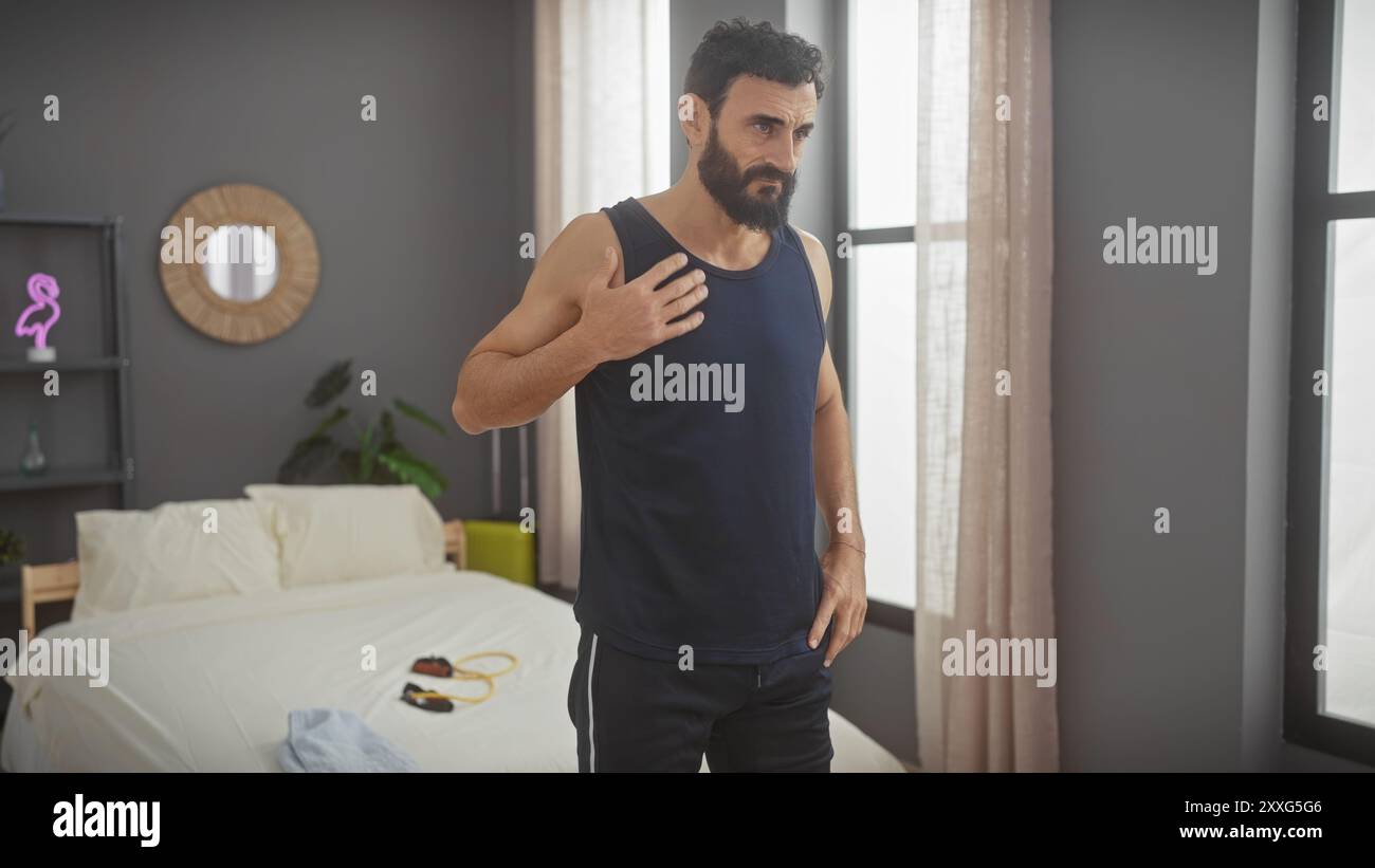 A bearded man in a bedroom with shoulder pain, expressing discomfort ...
