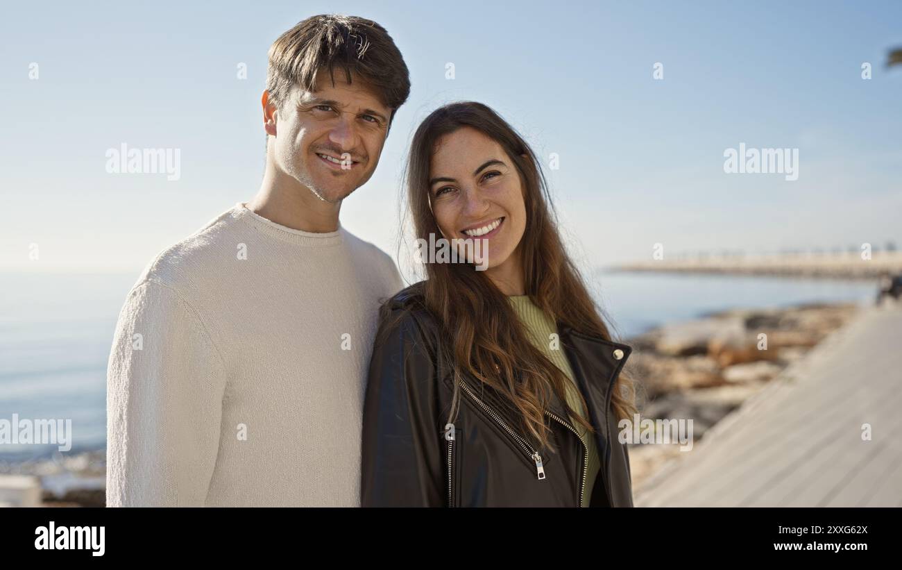 Happy couple enjoying a seaside stroll along the ocean promenade ...