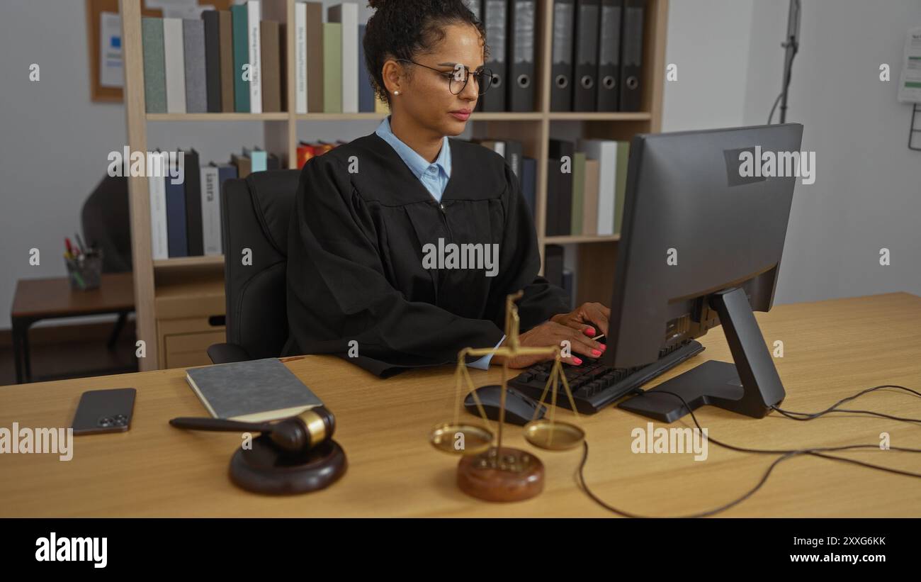 Young woman lawyer in a courtroom working on a computer, dressed in ...