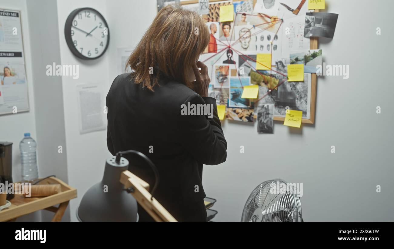 A woman analyzes evidence on a corkboard in a detective office ...