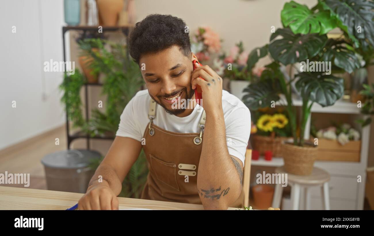 Smiling african american man making a phone call in an indoor flower ...
