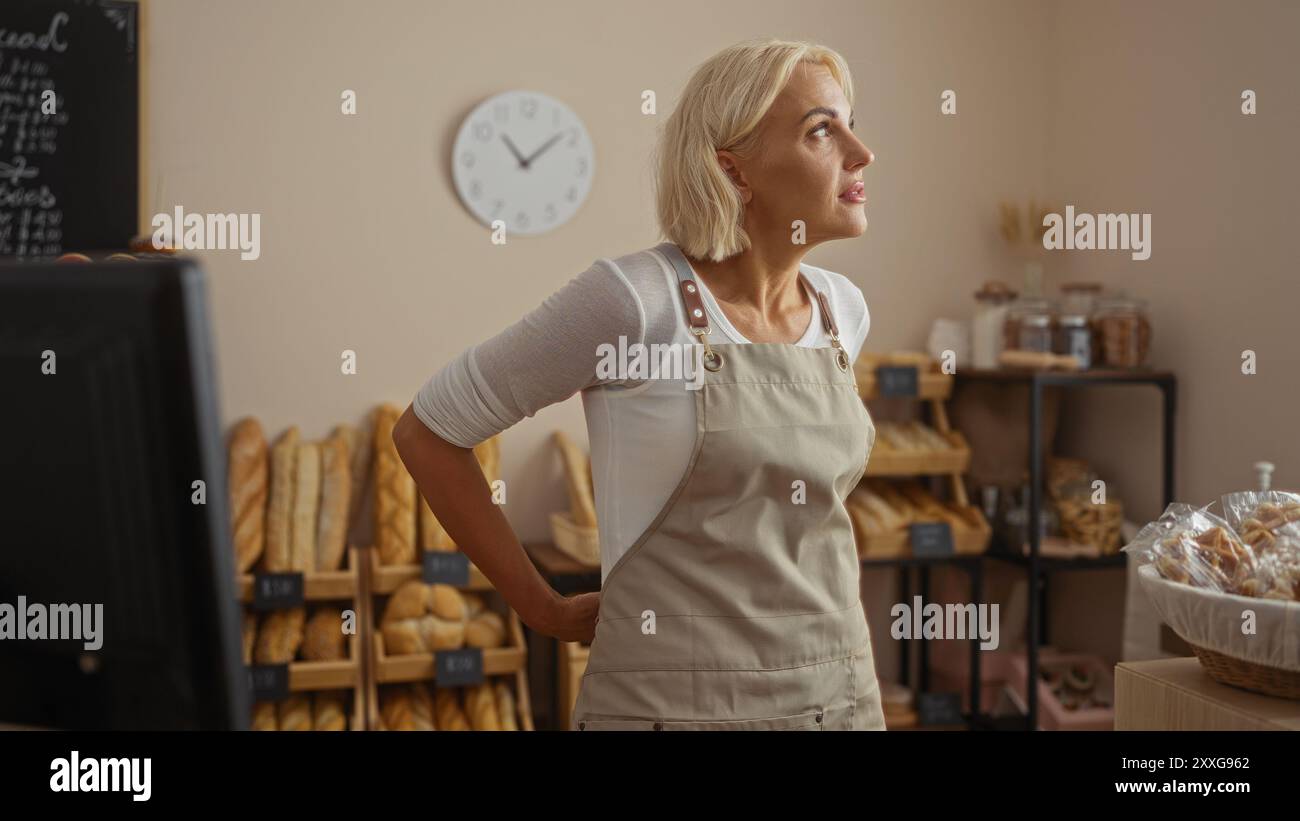 Woman tying apron in bakery room with blonde short hair, surrounded by ...