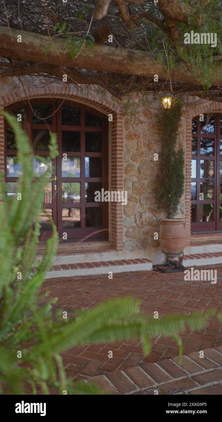 Mediterranean villa with terracotta tiles, arches, potted plant, and ...