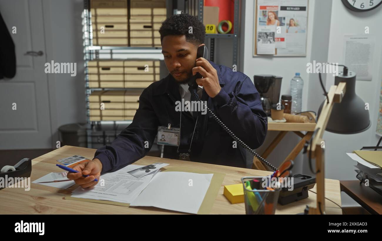 African american male detective working at his desk with documents and ...