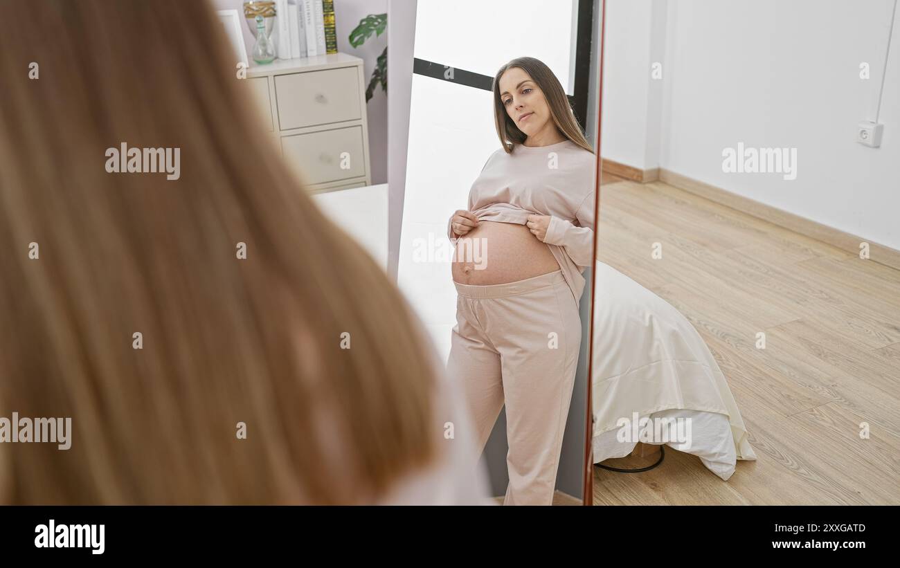 A hispanic pregnant woman contemplates her reflection in a bedroom ...