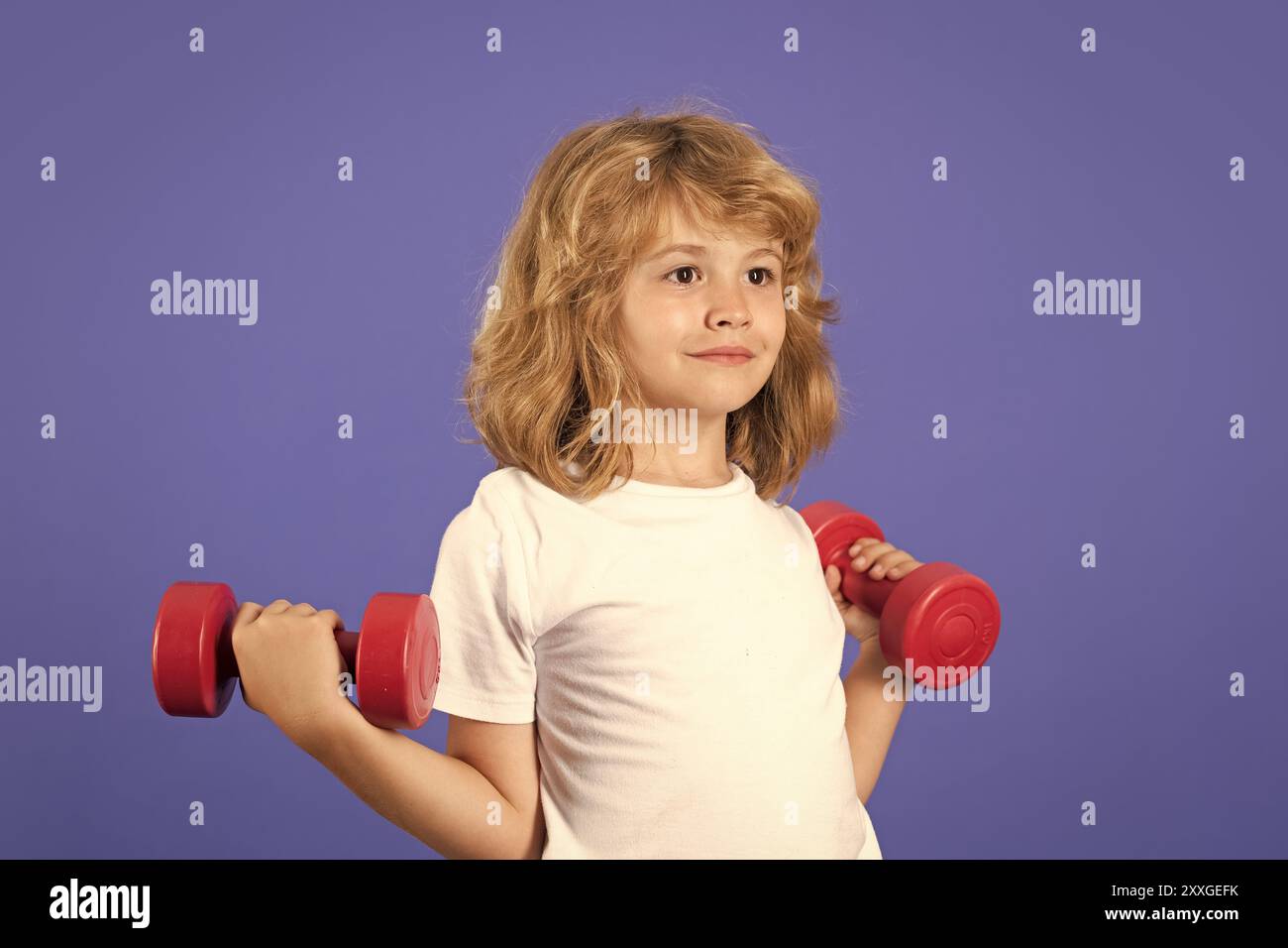 Kid raising a dumbbell. Cute child training with dumbbells. Kids ...