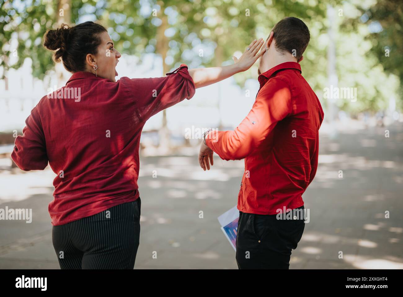 Woman hitting man in the face in park representing conflict and anger ...