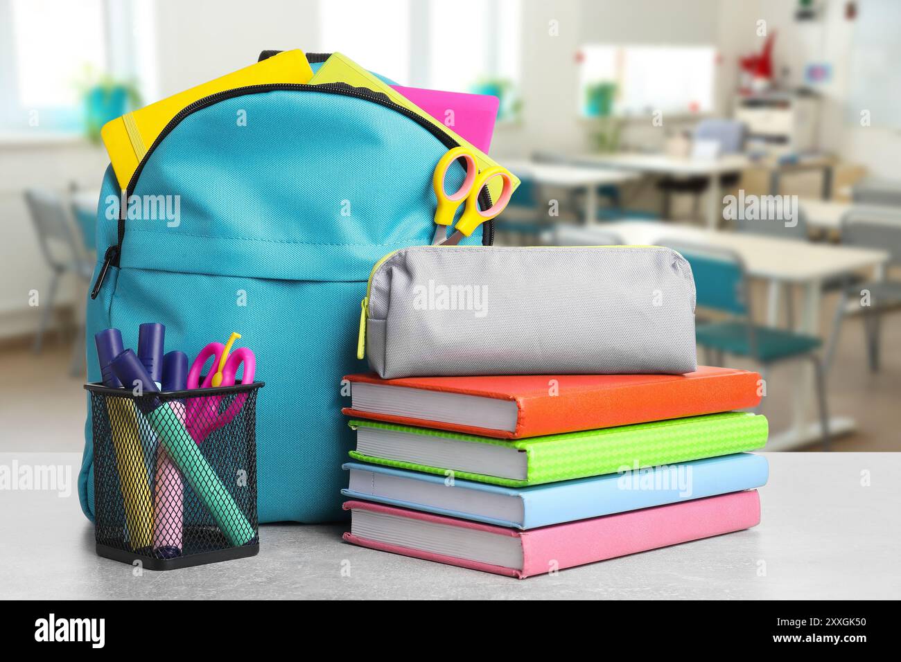 Light blue backpack with stationery on school desk in classroom Stock ...