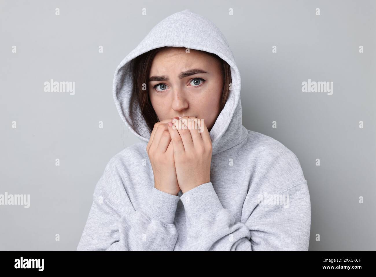 Portrait of scared woman on light background Stock Photo - Alamy