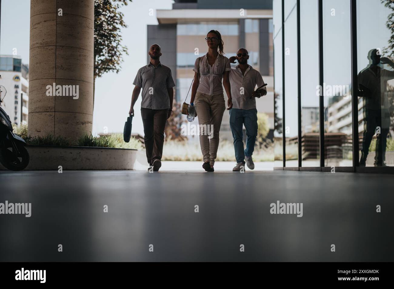 Businesspeople walking together in an urban downtown area, having an ...