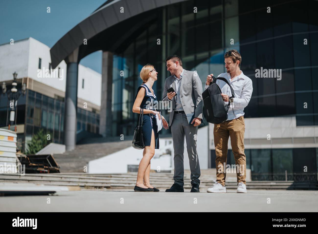 Business professionals having a conversation outside modern office ...