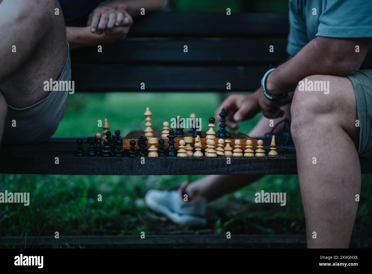 Two people playing chess on a wooden park bench outdoors Stock Photo ...
