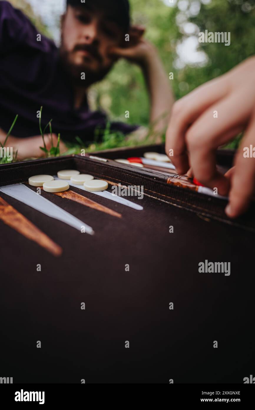 Man enjoying an outdoor backgammon game in a park Stock Photo - Alamy