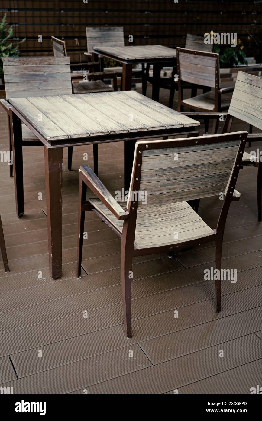 Cafe tables lined up in the wooden deck courtyard Stock Photo - Alamy