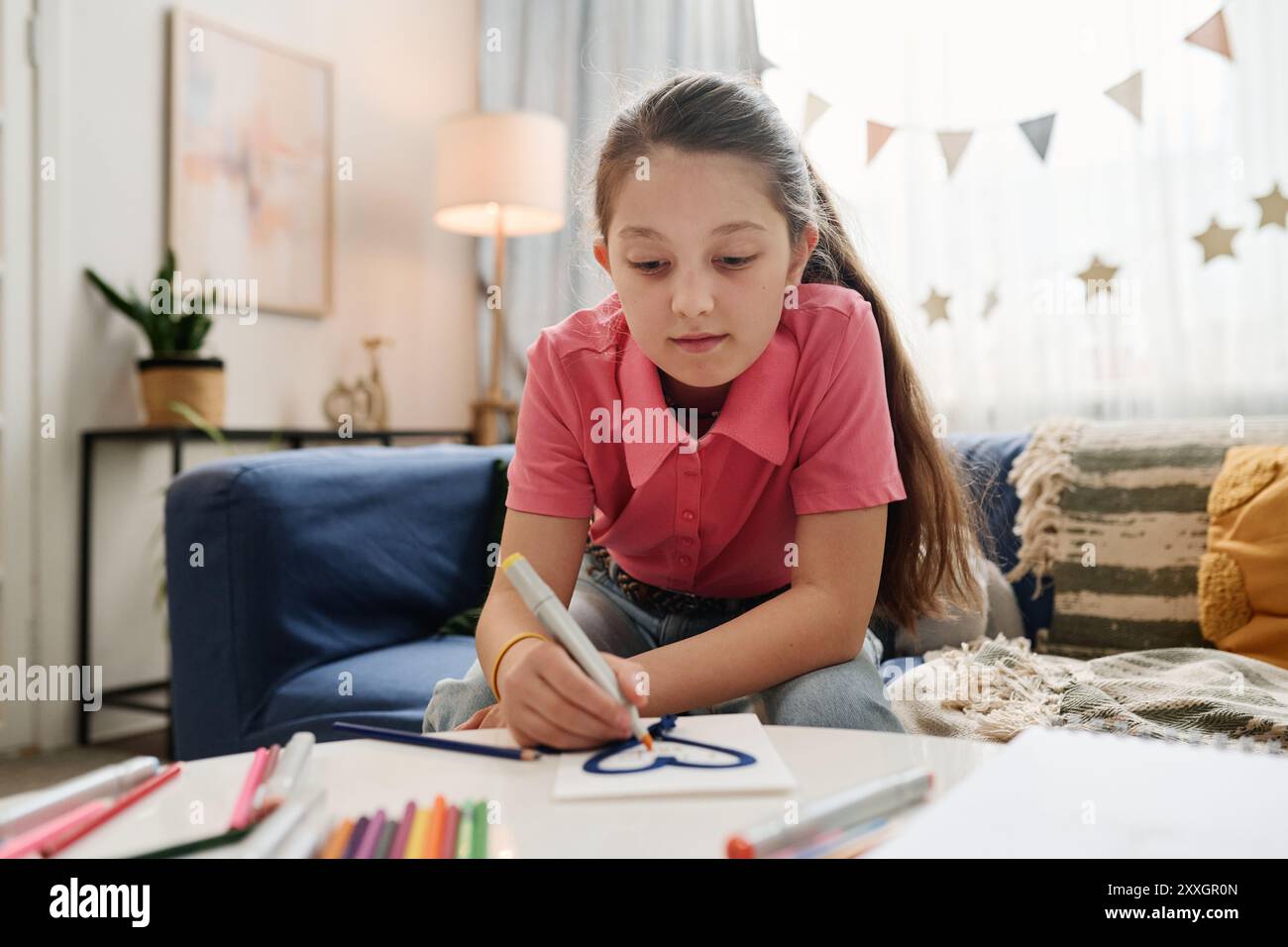 Young girl concentrating on drawing with crayons in warm, inviting ...
