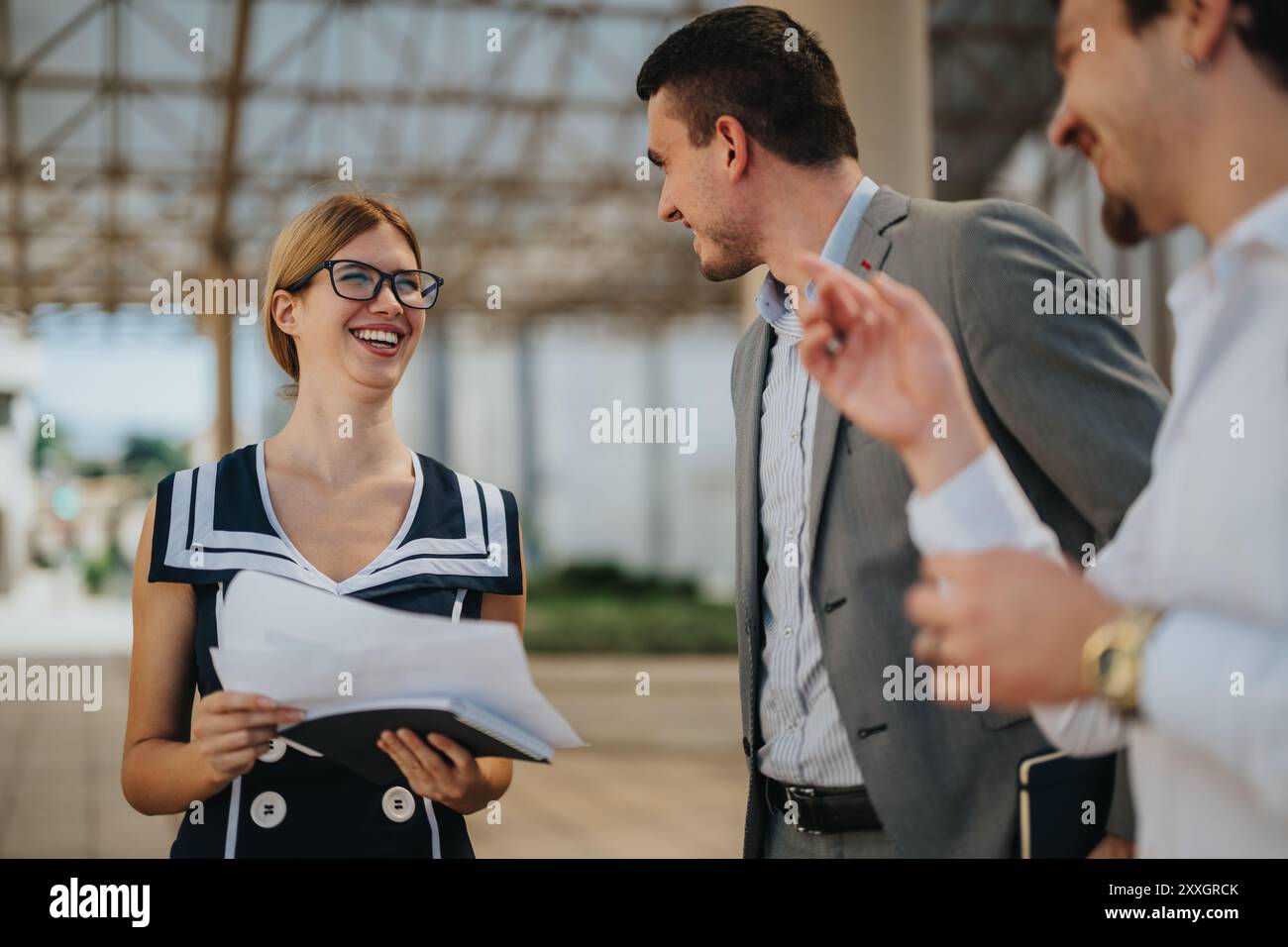 Young business professionals sharing a laugh during an outdoor meeting ...