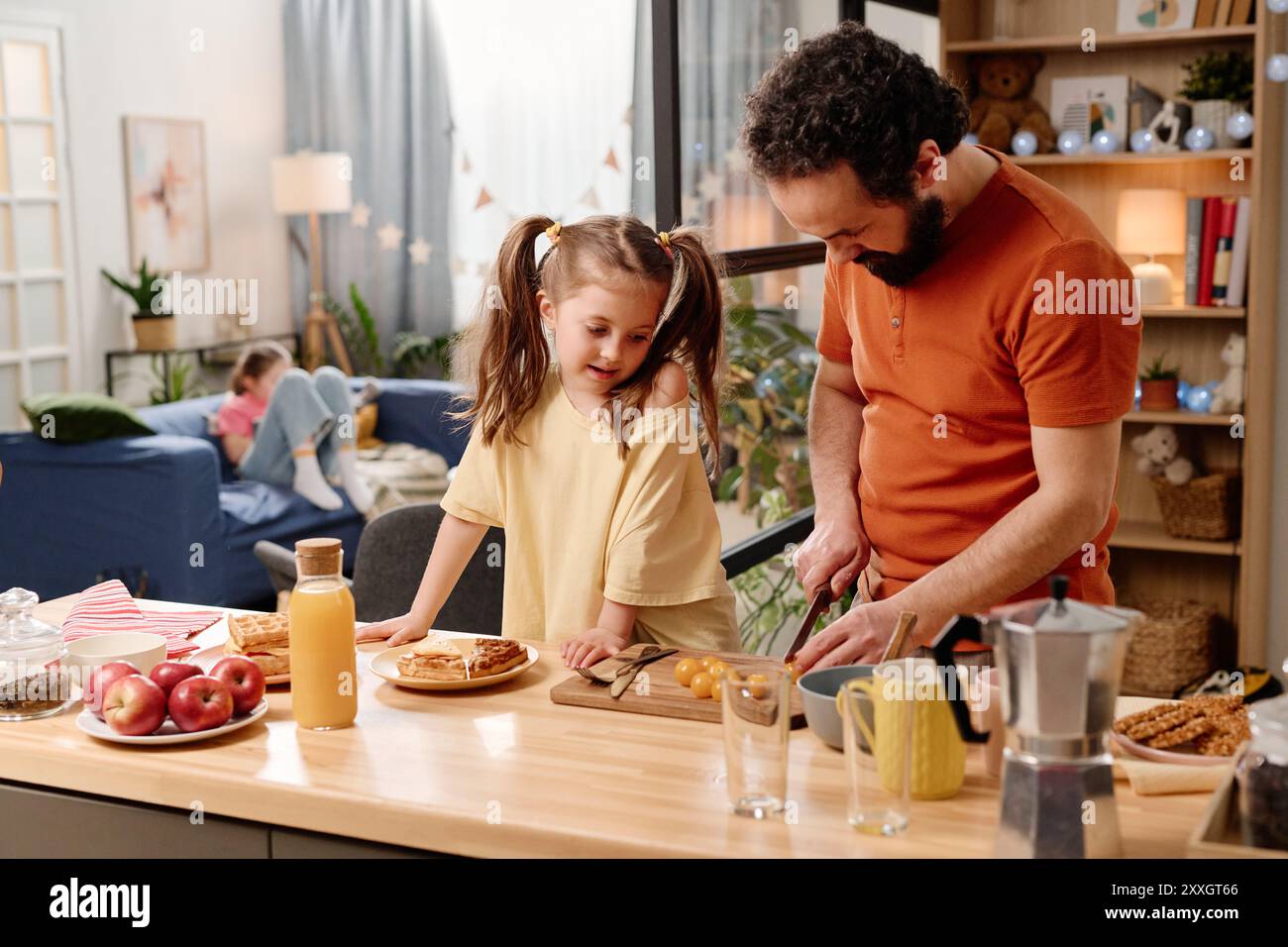 Father and daughter preparing breakfast together in cozy modern kitchen ...