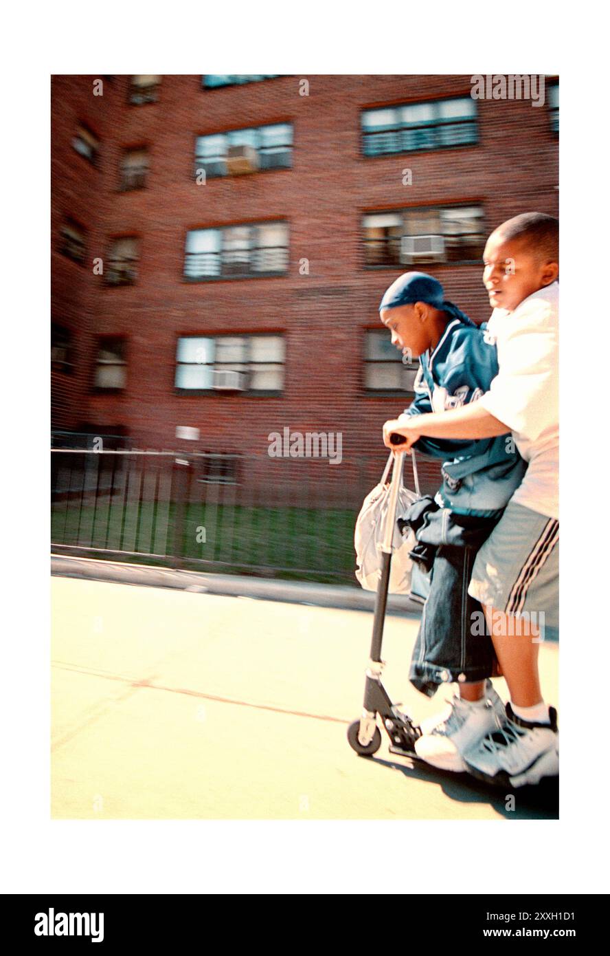 New York, New York, USA, February 28th 2002; Kids playing on a scooter ...