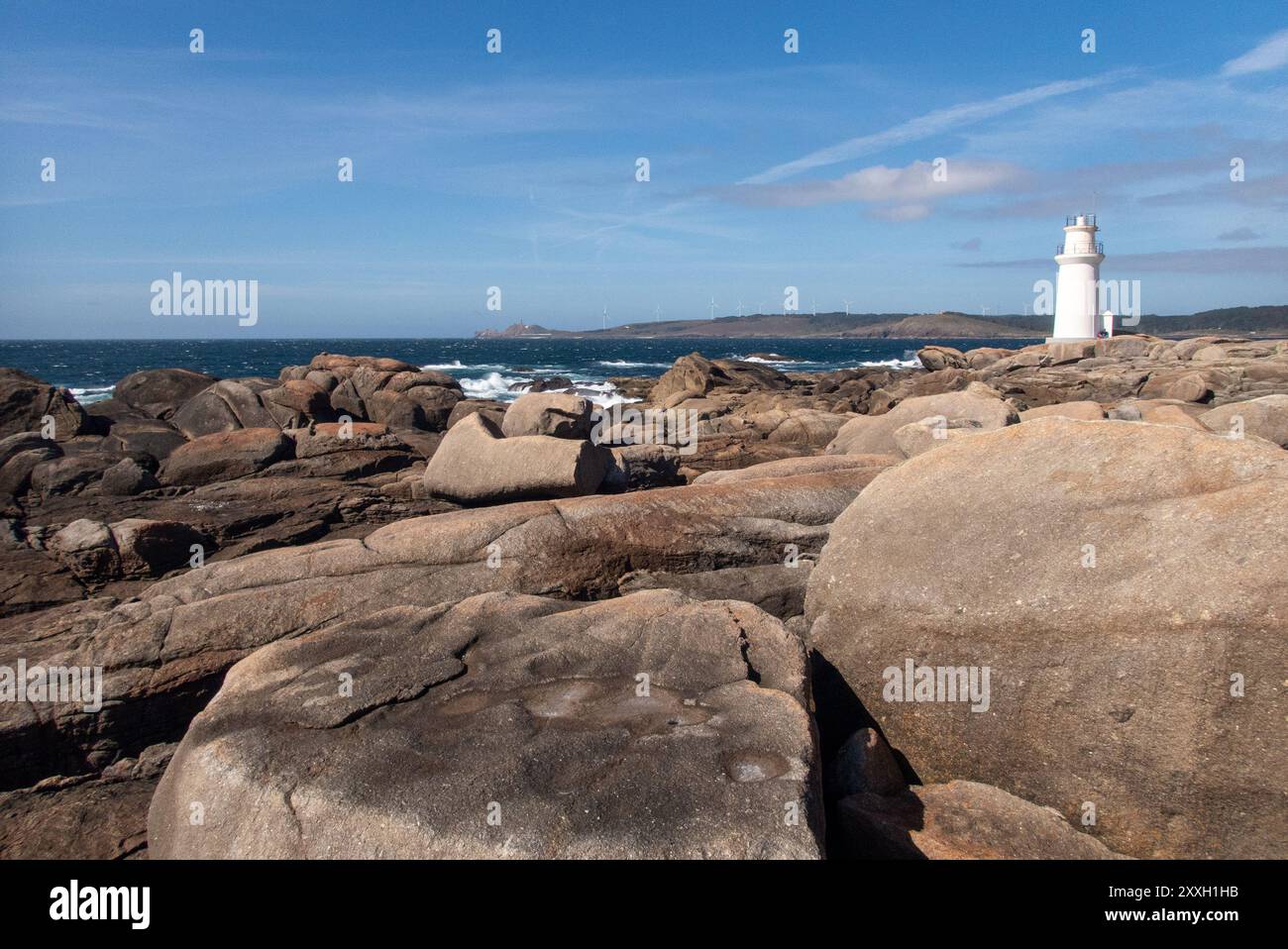 Lighthouse on the rocks: Waves of the Atlantic crash against the rocky ...