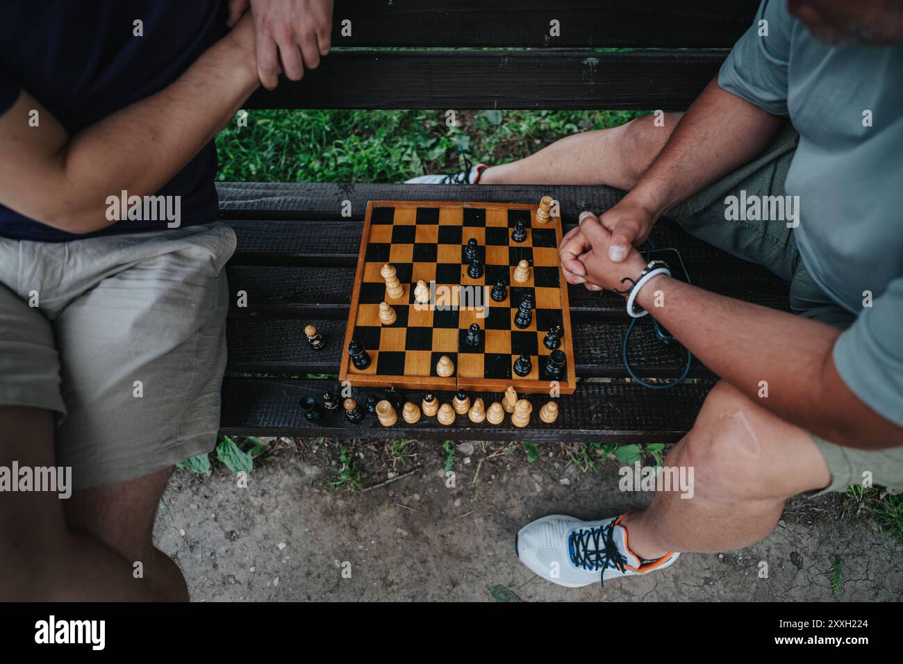 Two friends playing chess on a park bench from top view Stock Photo - Alamy