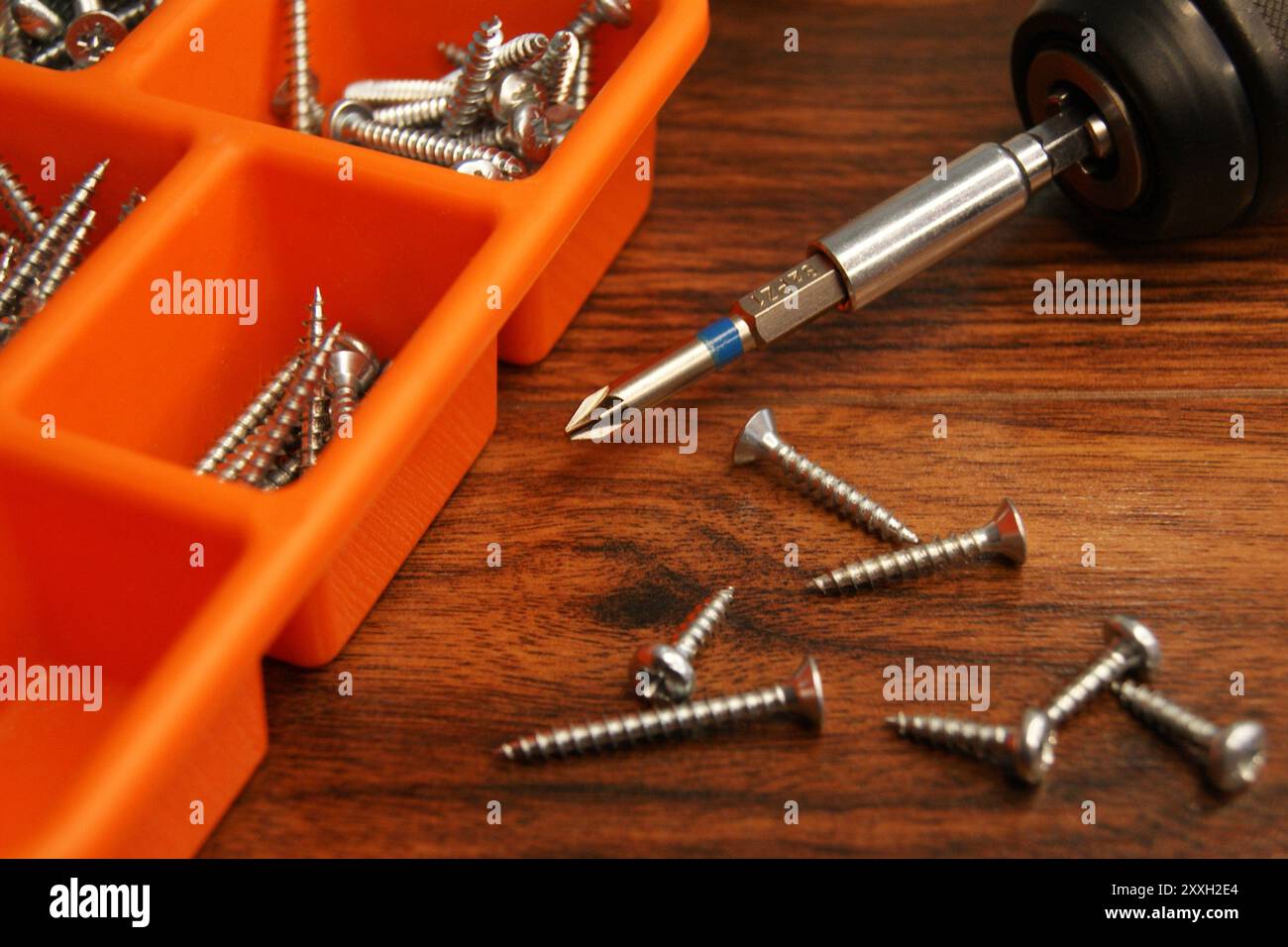 Red screw box and screwdriver on the table. Fitter's place of work ...