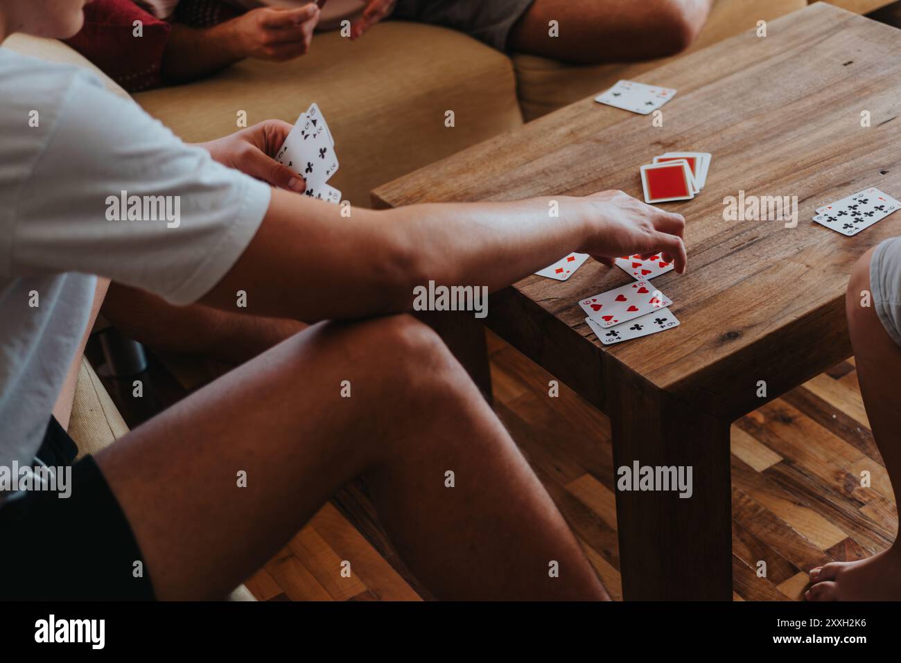 Boys playing cards game around a wooden table at home Stock Photo - Alamy