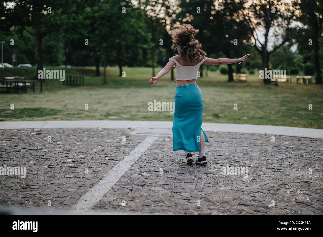 Young girl dancing freely in a green park, showcasing modern dance ...