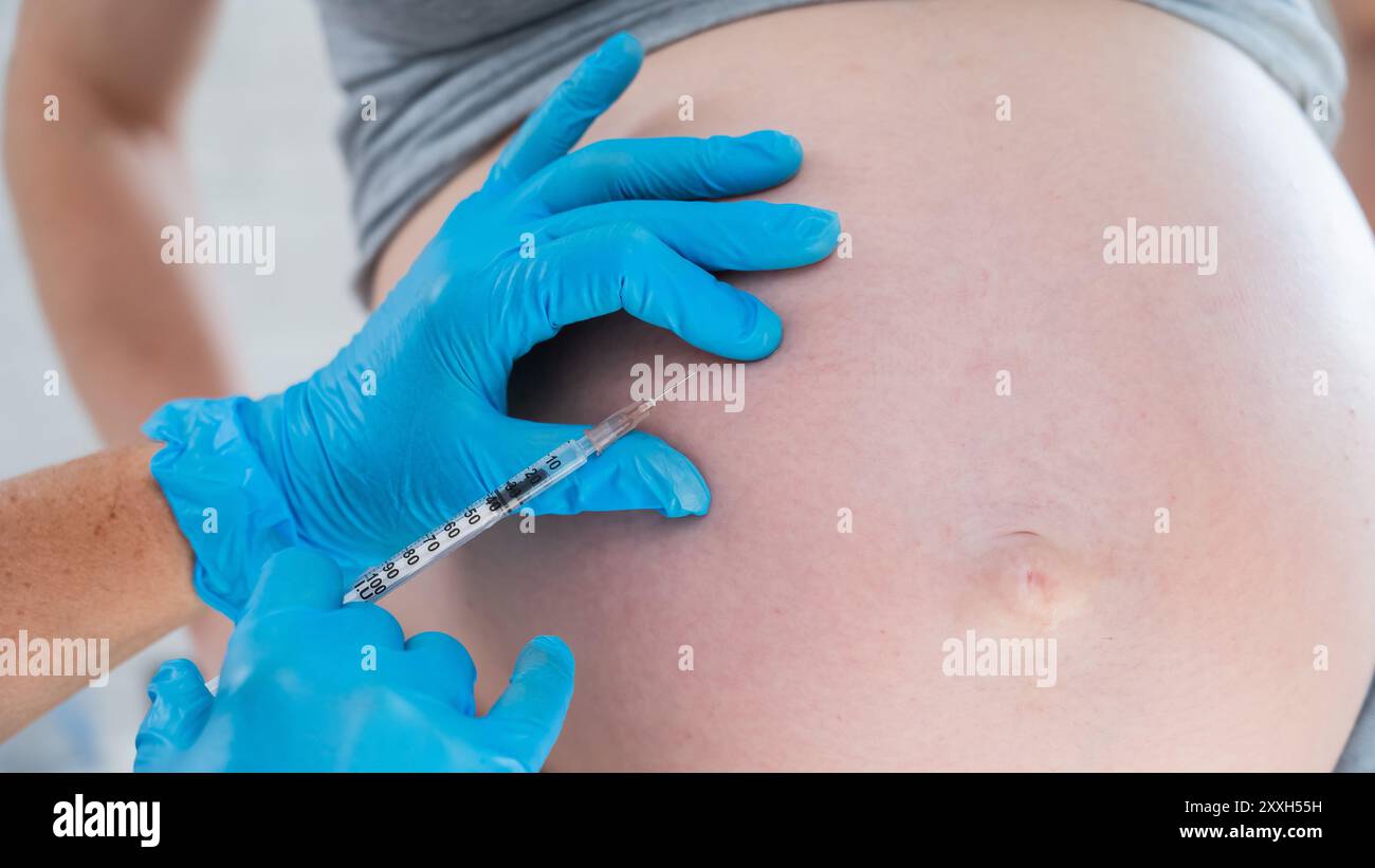Doctor gives an injection in the stomach of a pregnant woman Stock ...