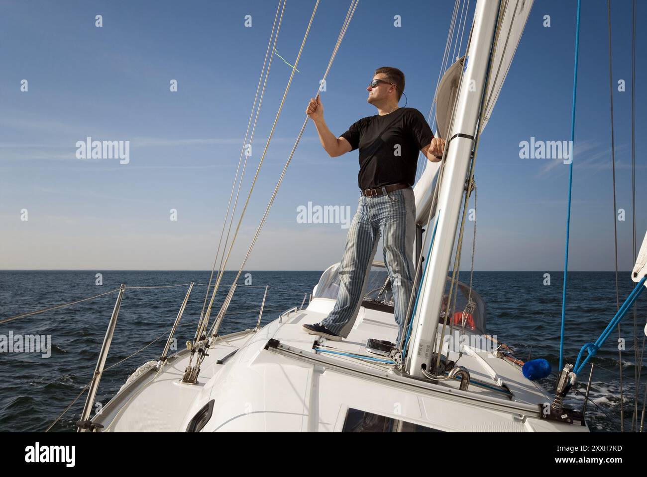 Skipper stands on the deck of his sailing yacht Stock Photo - Alamy