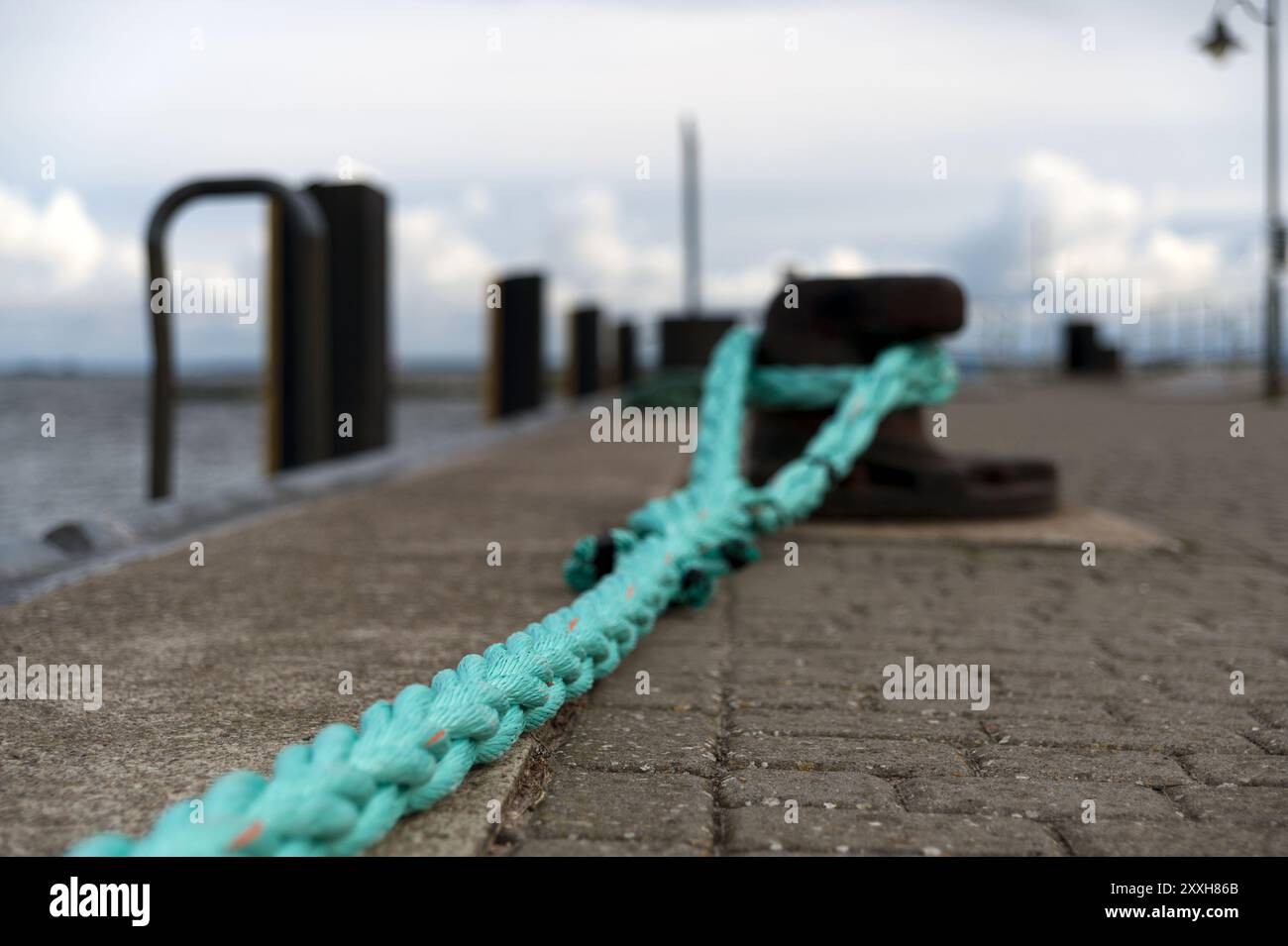 Bollard on the pier weighed down with ropes Stock Photo - Alamy