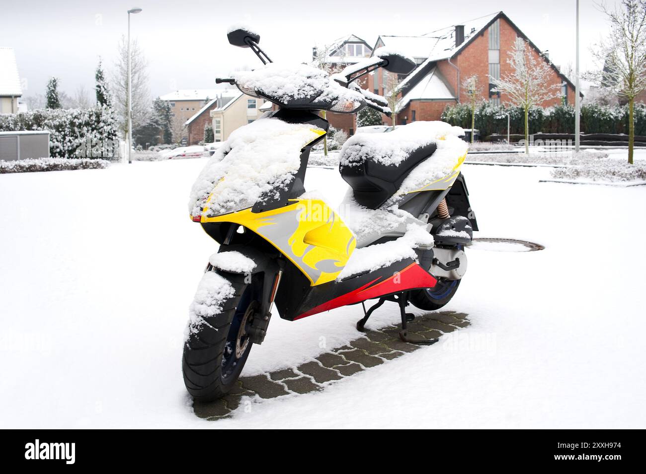Snow-covered moped in a car park Stock Photo - Alamy