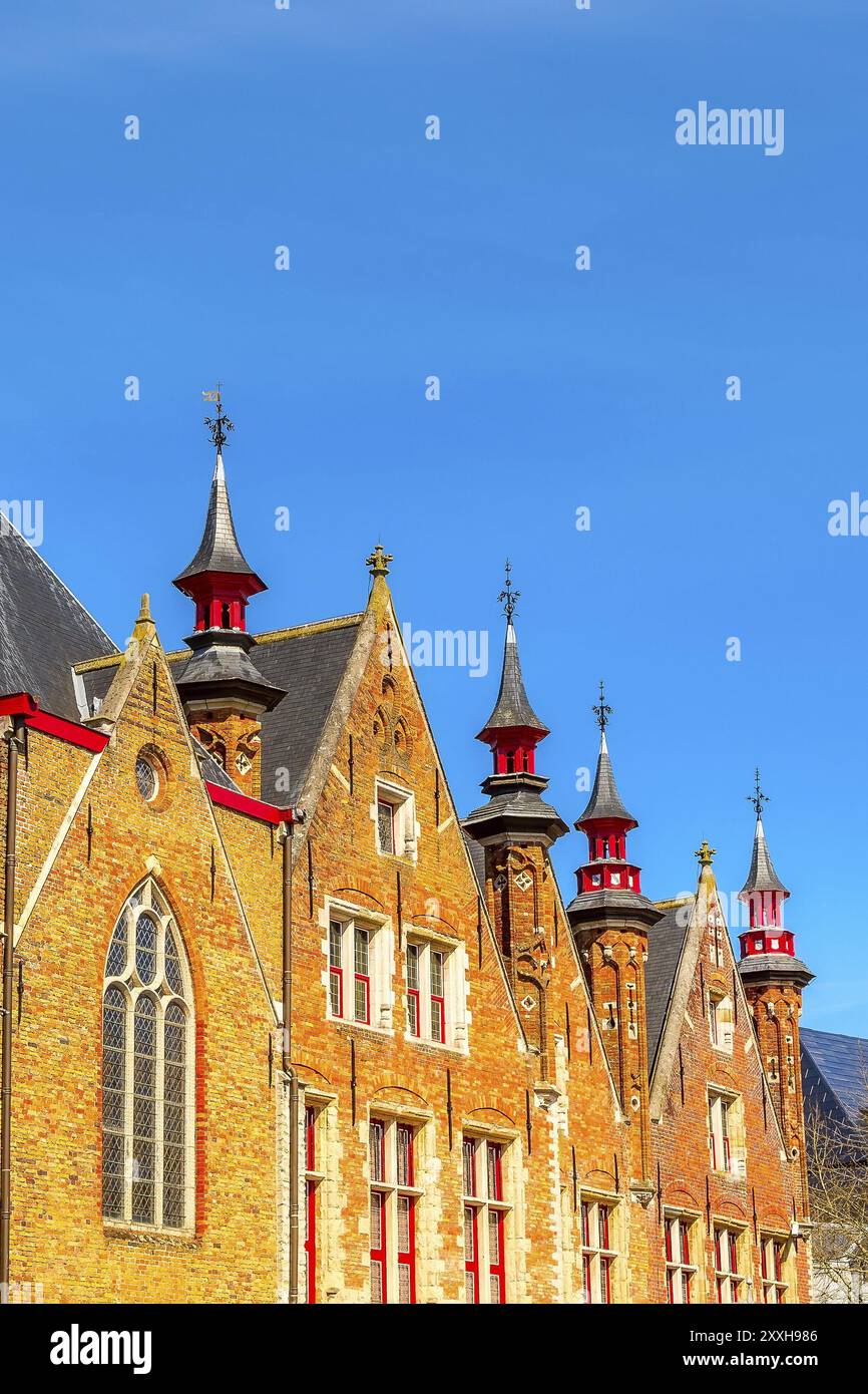 Traditional medieval brick house exterior against blue sky in Brugge ...