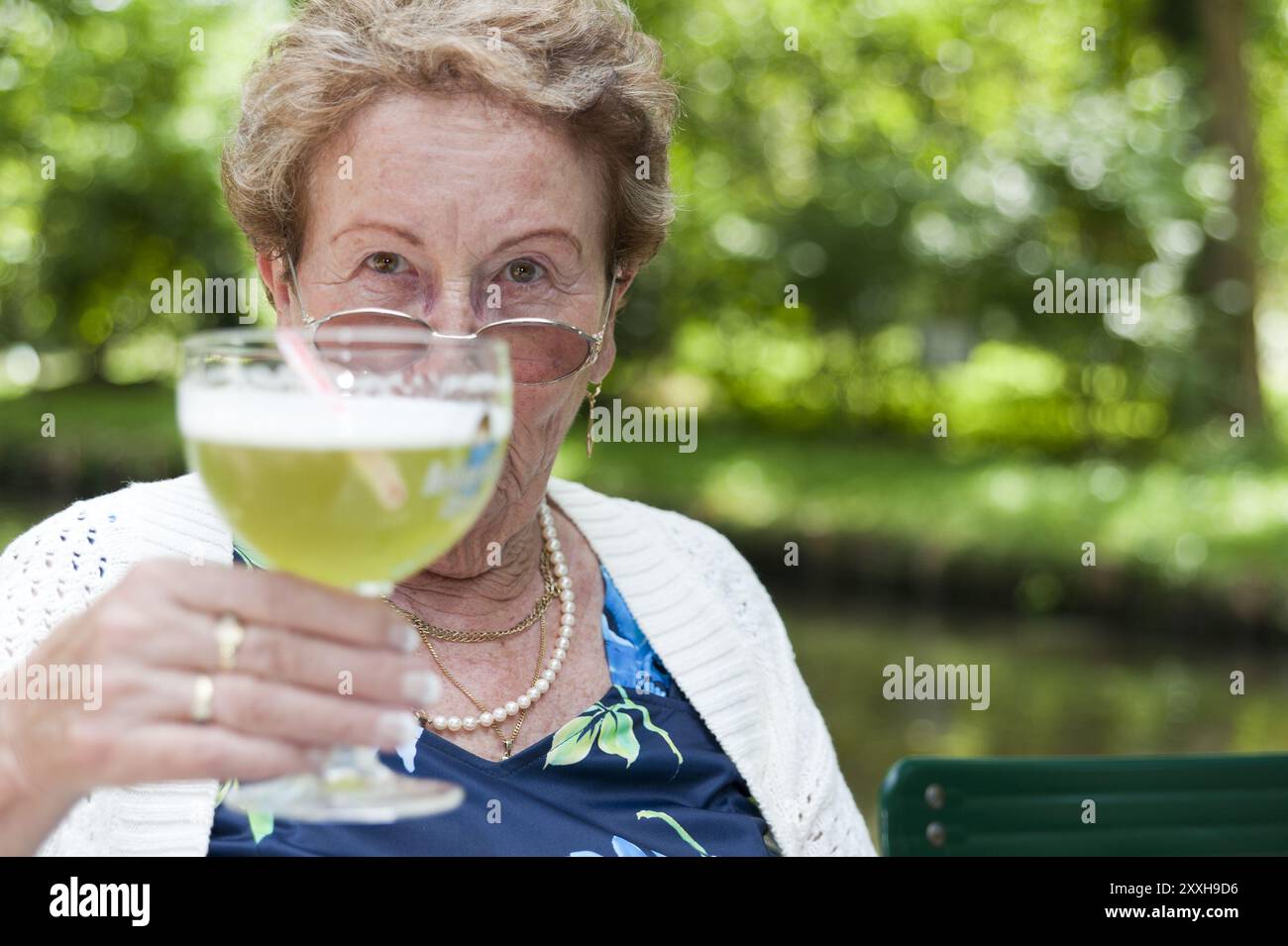 Old lady toasts the viewer with a glass of Berliner Weisse Stock Photo ...