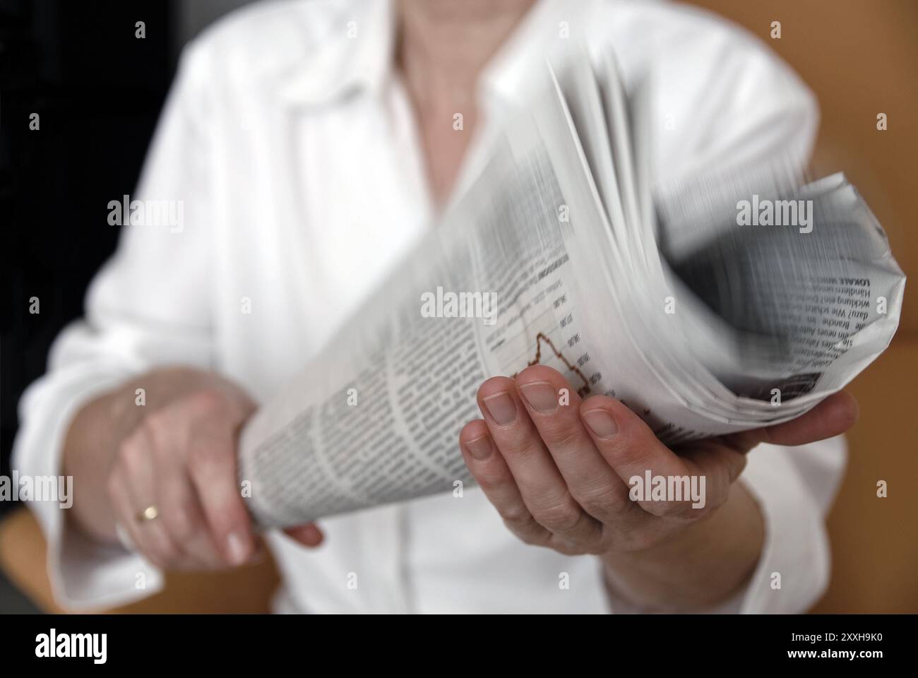 Woman with rolled up newspaper Stock Photo - Alamy