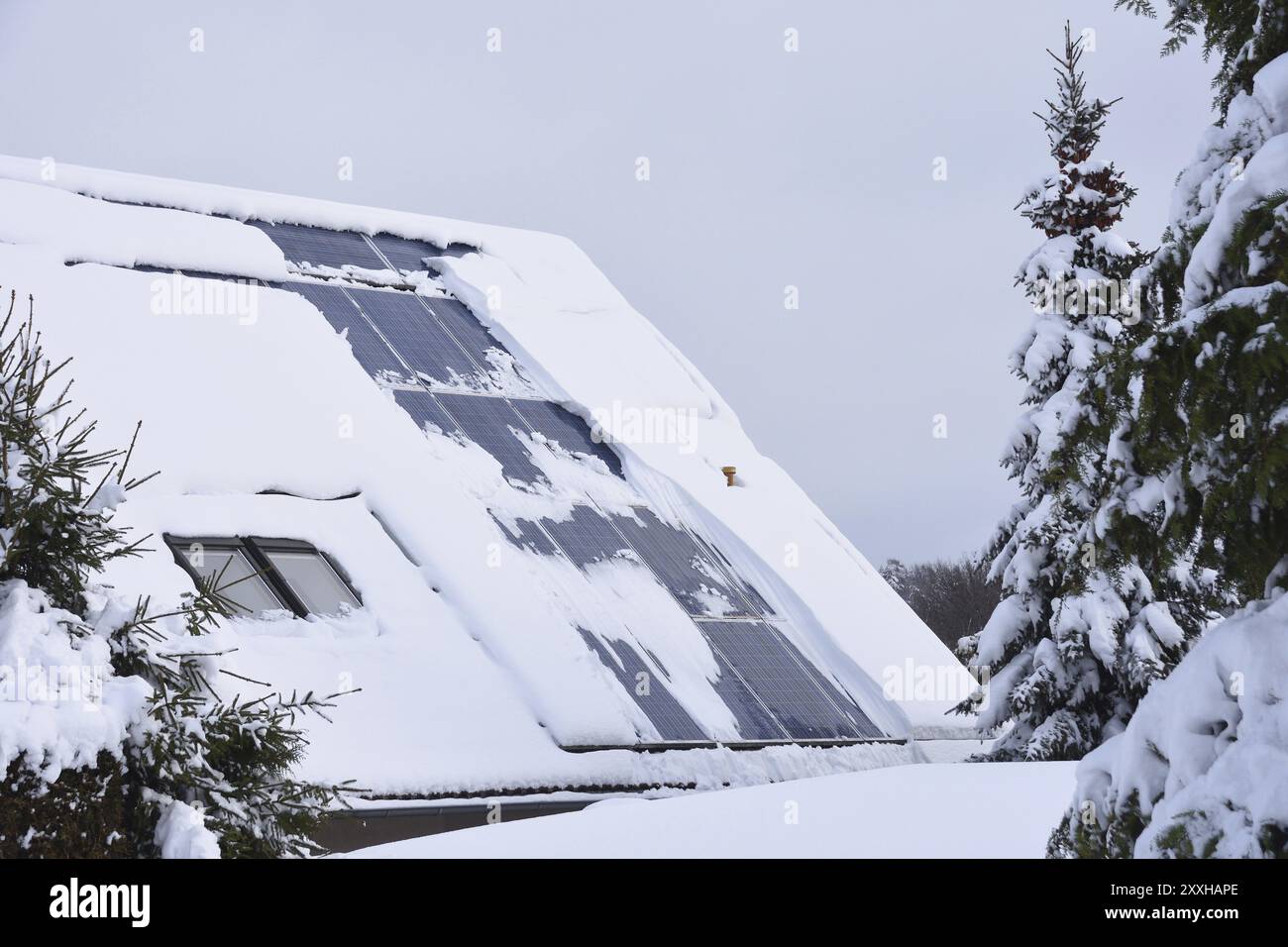 Snow-covered solar system on a house in winter. Solar system in winter ...