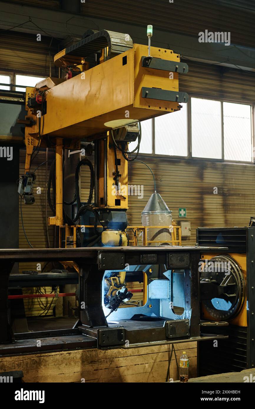 Heavy machinery operating inside an industrial facility constructed of ...