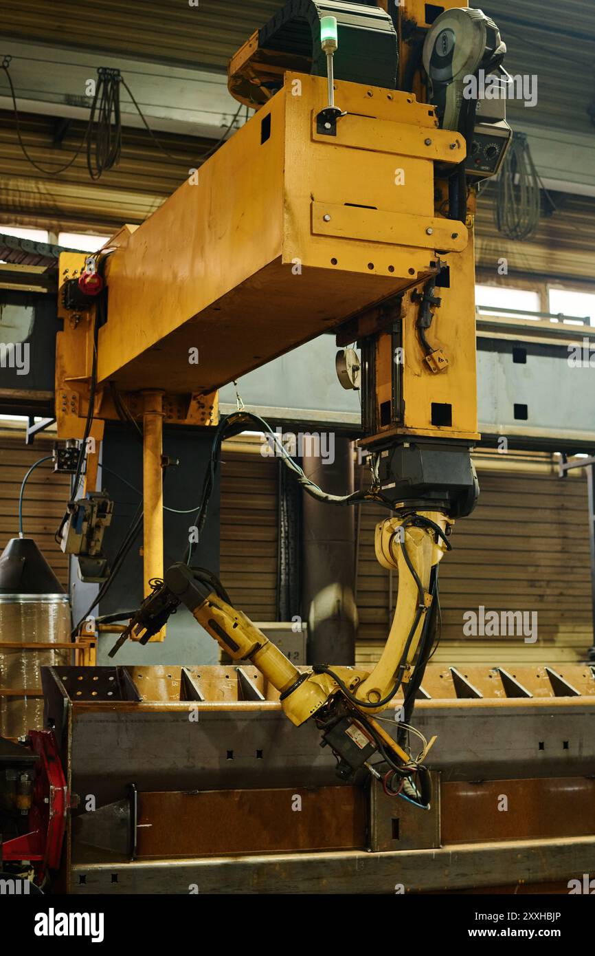 Industrial robot welding pieces of metal in factory creating sparks ...