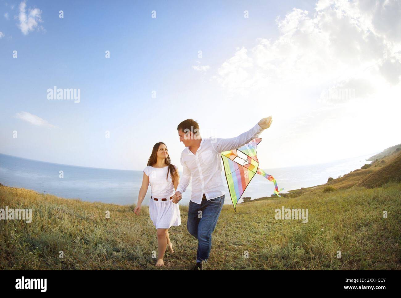 Happy young couple in love with flying a kite on the beach Stock Photo ...
