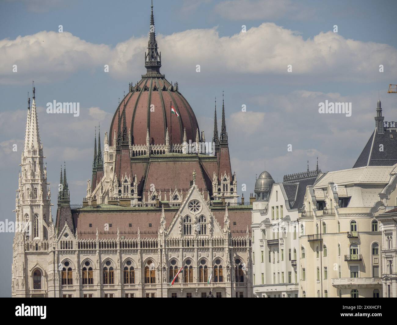 Neogothic parliament building with dome and towers, in front of a blue ...