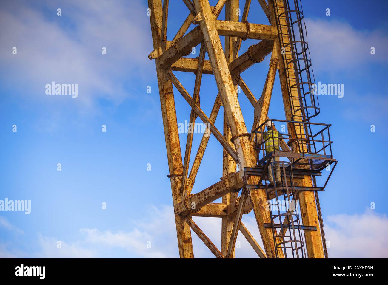 Worker climbing on a crane Stock Photo - Alamy