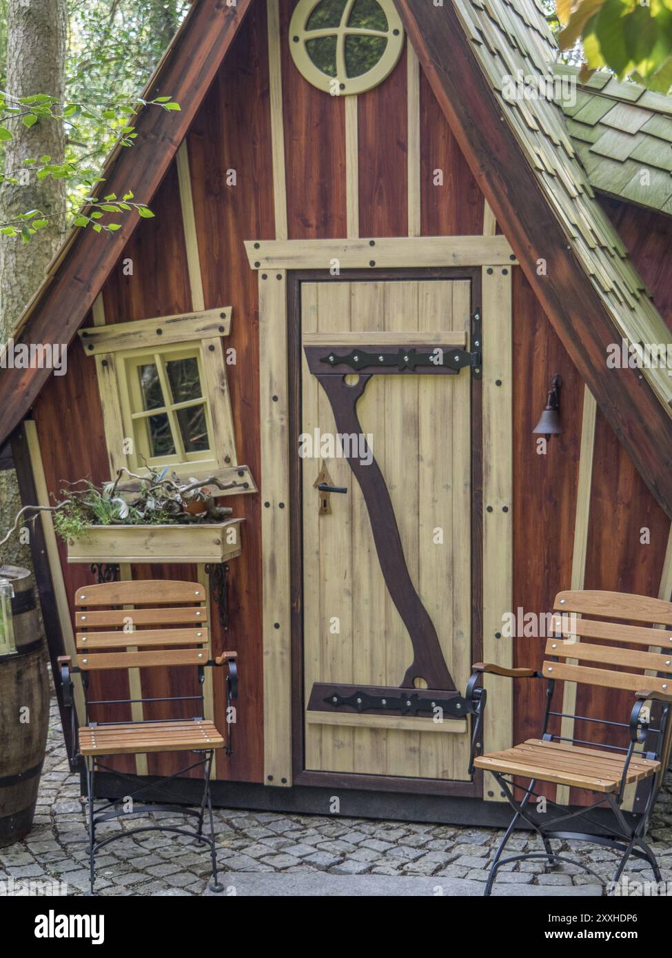 Rustic wooden hut in the forest with cosy chairs, wooden window and ...