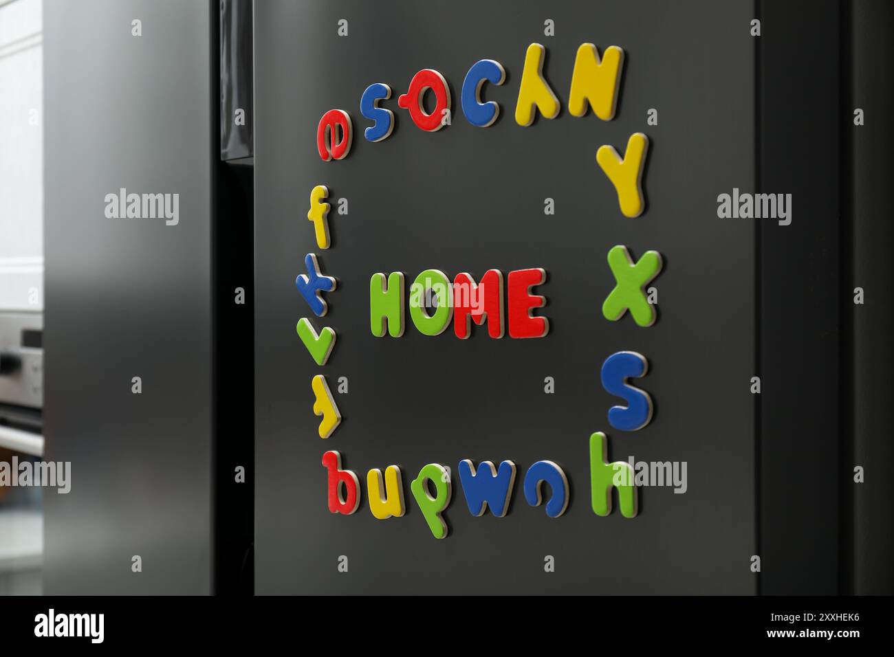Word Home and frame made of many bright magnetic letters on fridge ...